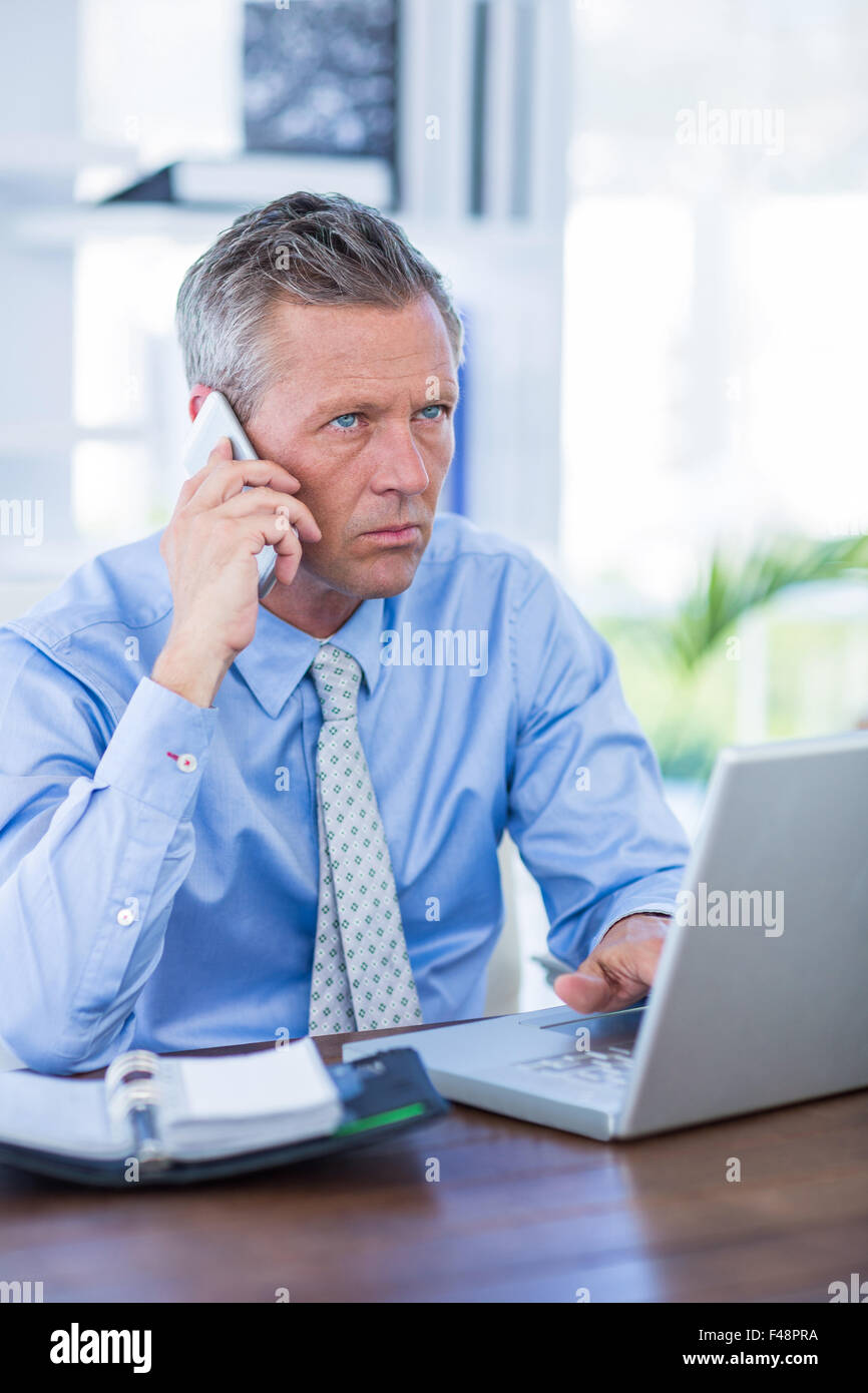 Serious businessman having phone call Stock Photo - Alamy
