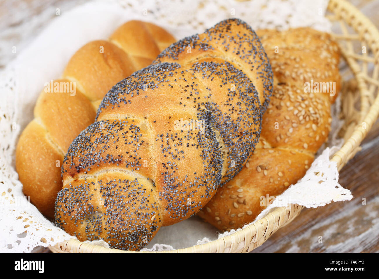 Challah bread with poppy seeds, sesame seeds and plain in bread basket ...