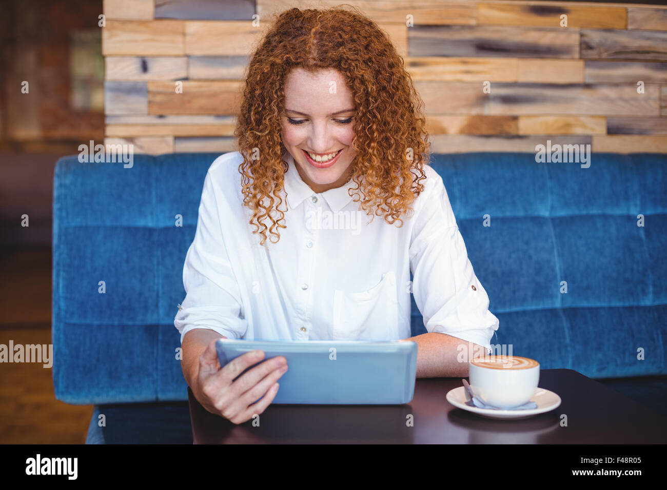Pretty girl using a small tablet at table Stock Photo - Alamy