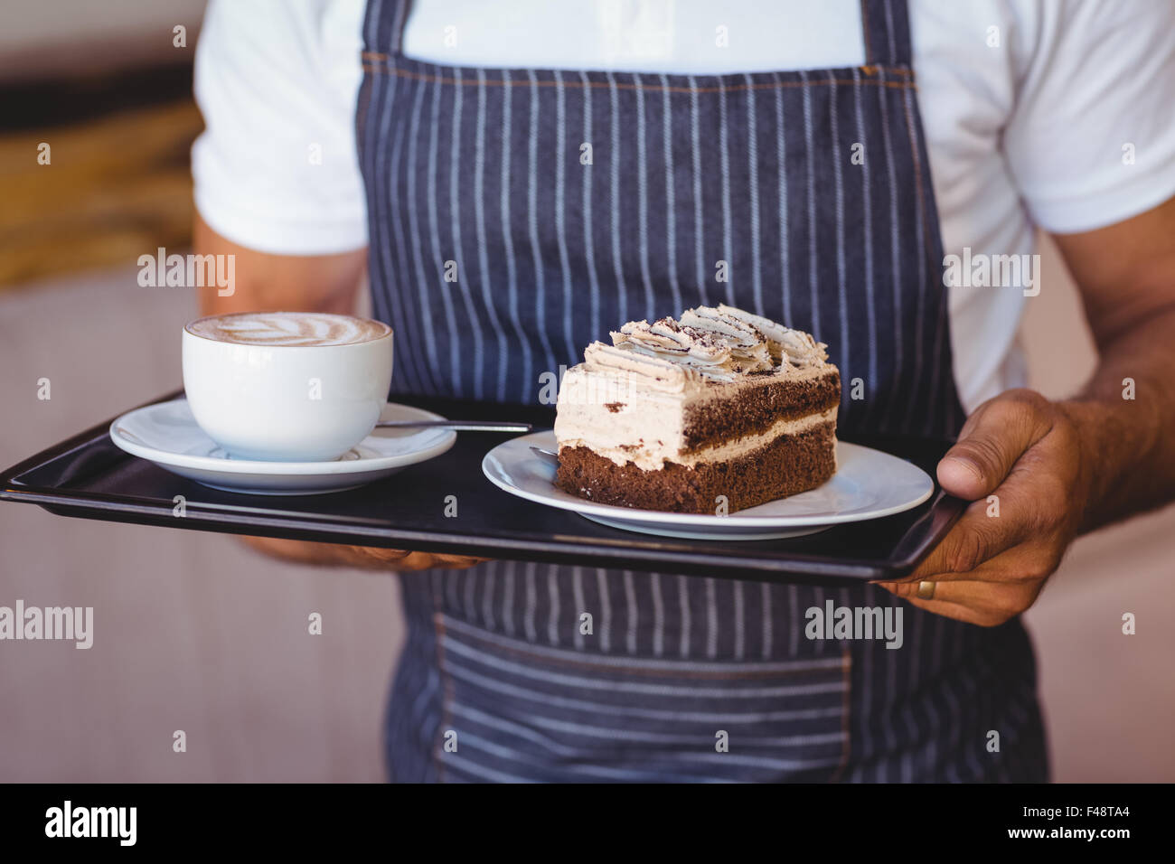 waiter smiling and holding tray Stock Photo - Alamy