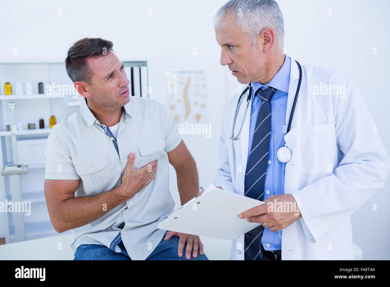 Serious doctor speaking with his patient Stock Photo - Alamy