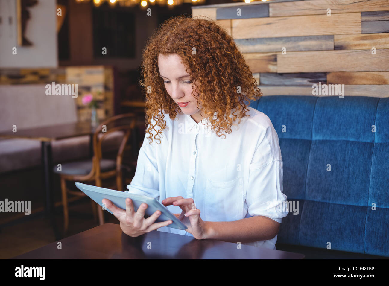 Pretty girl using a small tablet at table Stock Photo - Alamy
