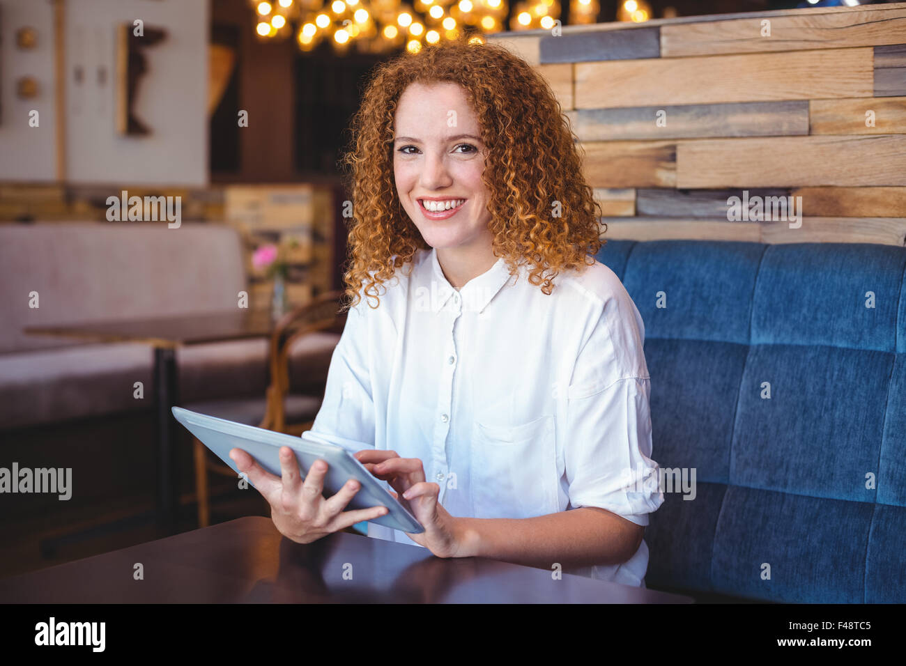 Pretty girl using a small tablet at table Stock Photo - Alamy