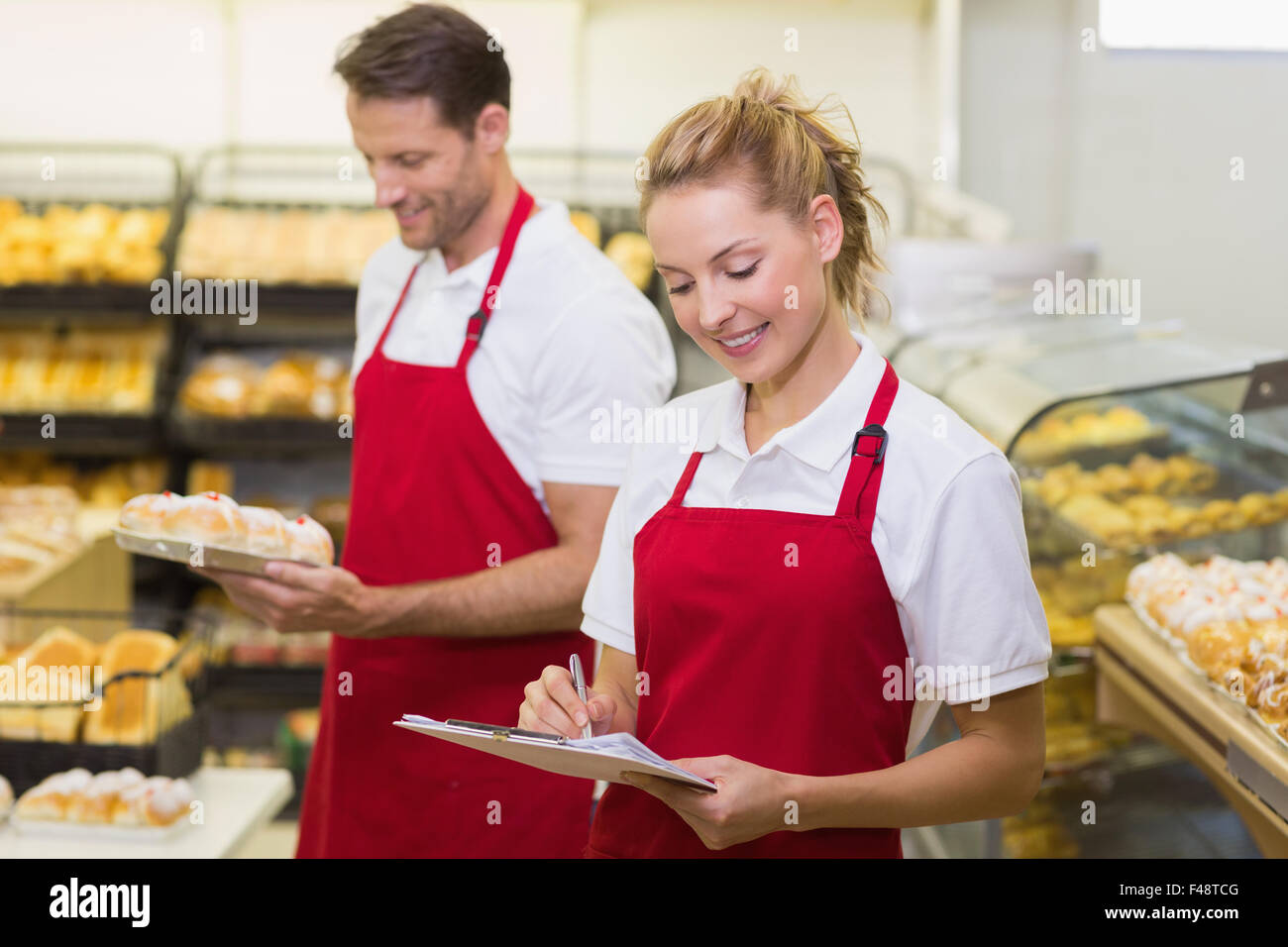 Two smiling colleagues writing on notepad Stock Photo - Alamy