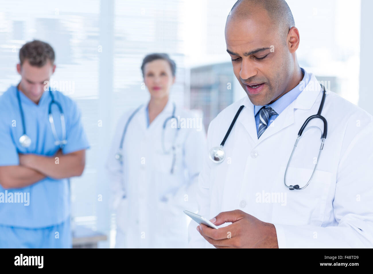 Attentive doctor sending a text message Stock Photo - Alamy