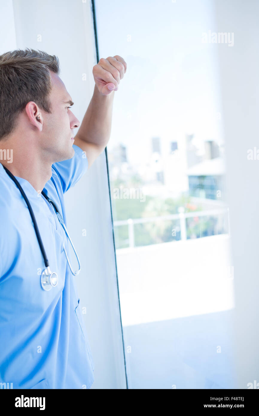 Thoughtful doctor looking through the windows Stock Photo - Alamy