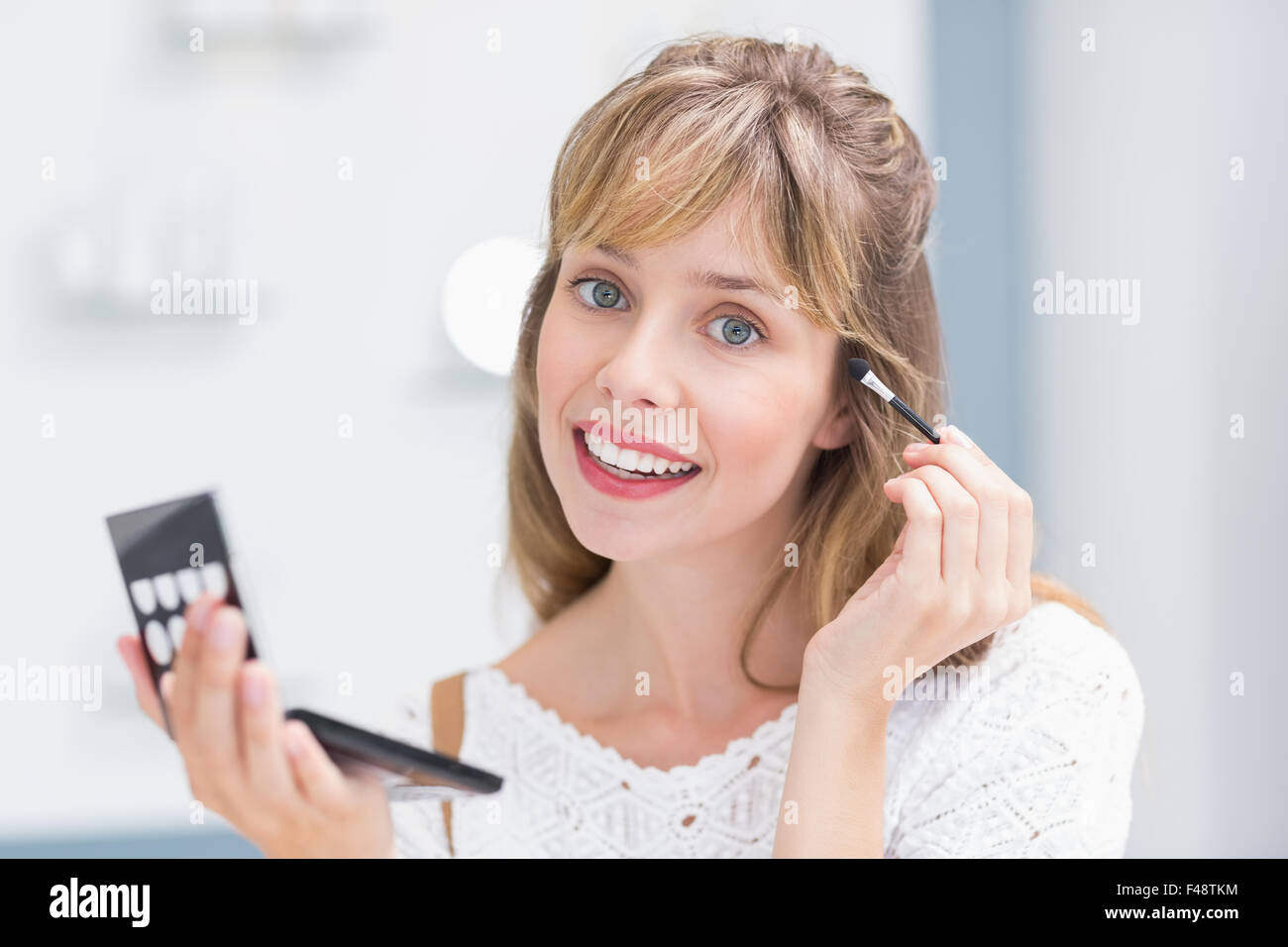 Beautiful costumer putting on makeup Stock Photo - Alamy