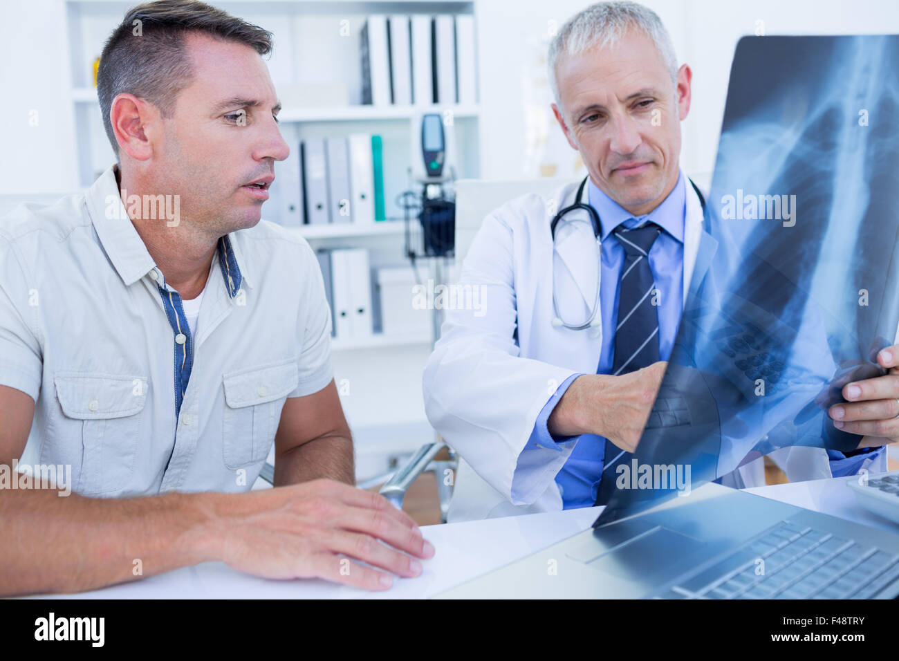 Doctor and patient looking at Xray Stock Photo - Alamy