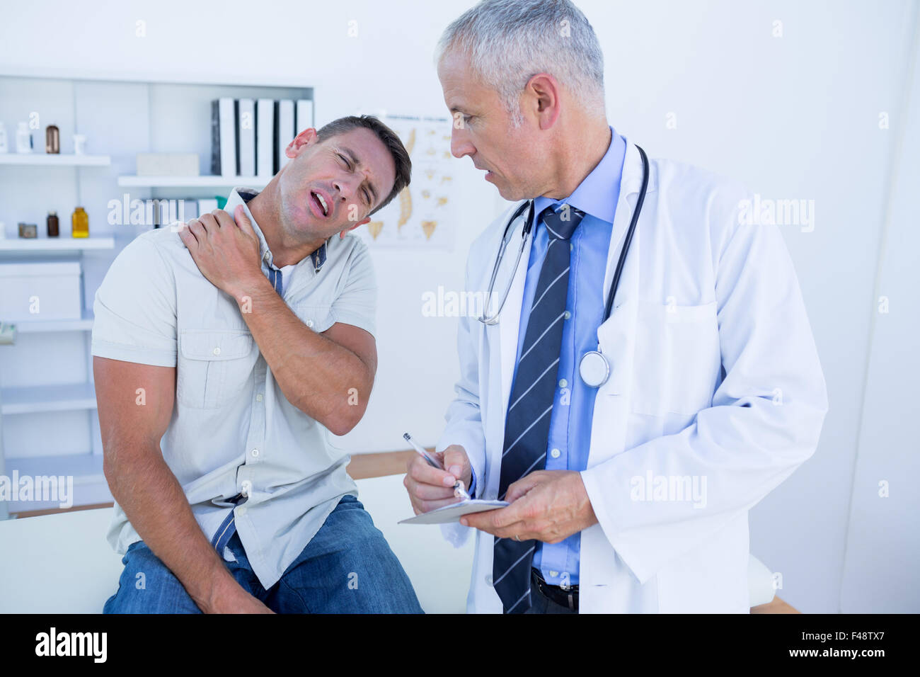 Doctor looking at patient shoulder Stock Photo - Alamy