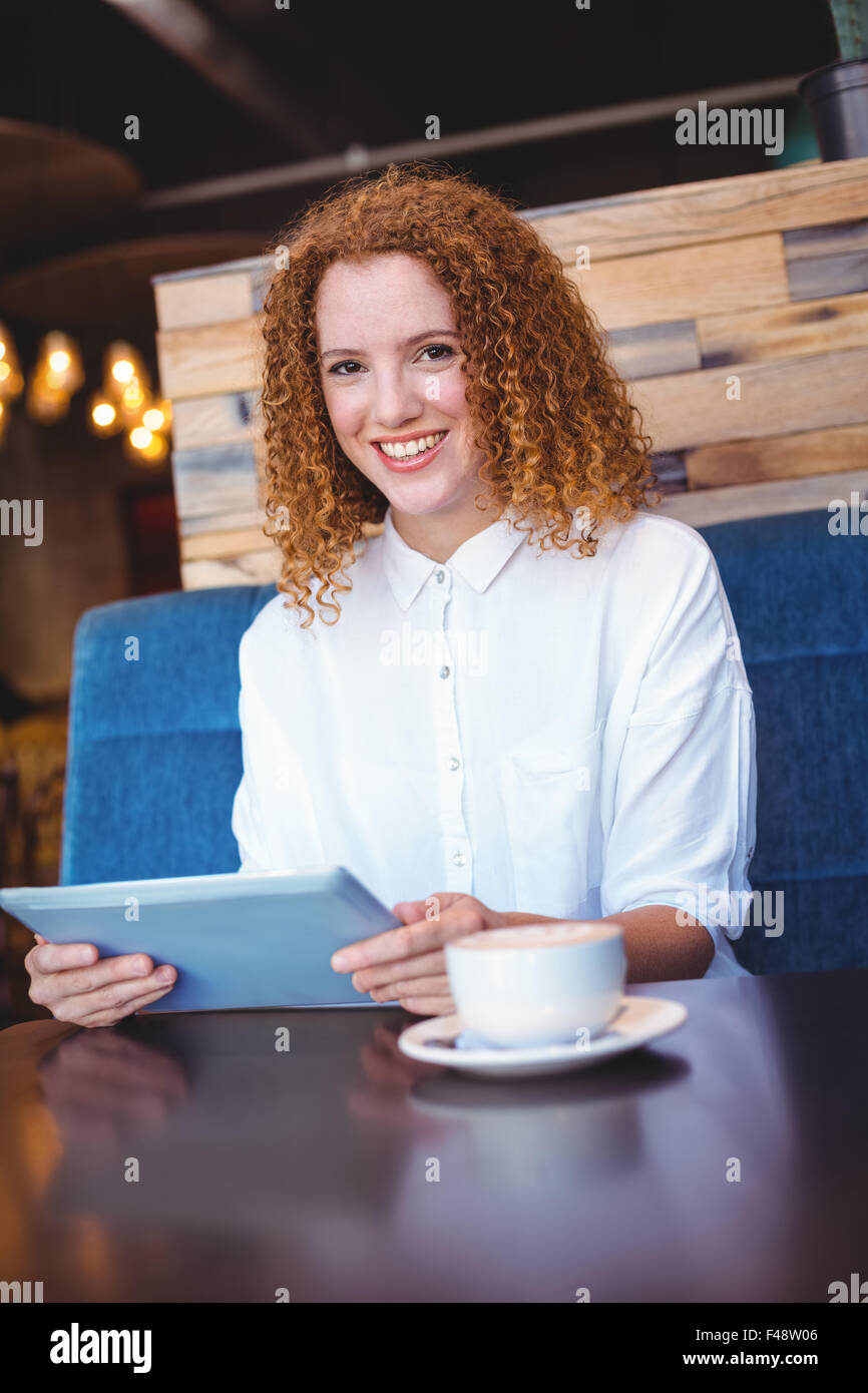 Pretty girl using a small tablet at table Stock Photo - Alamy