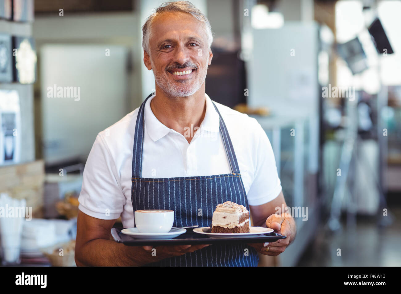 waiter smiling and holding tray Stock Photo - Alamy