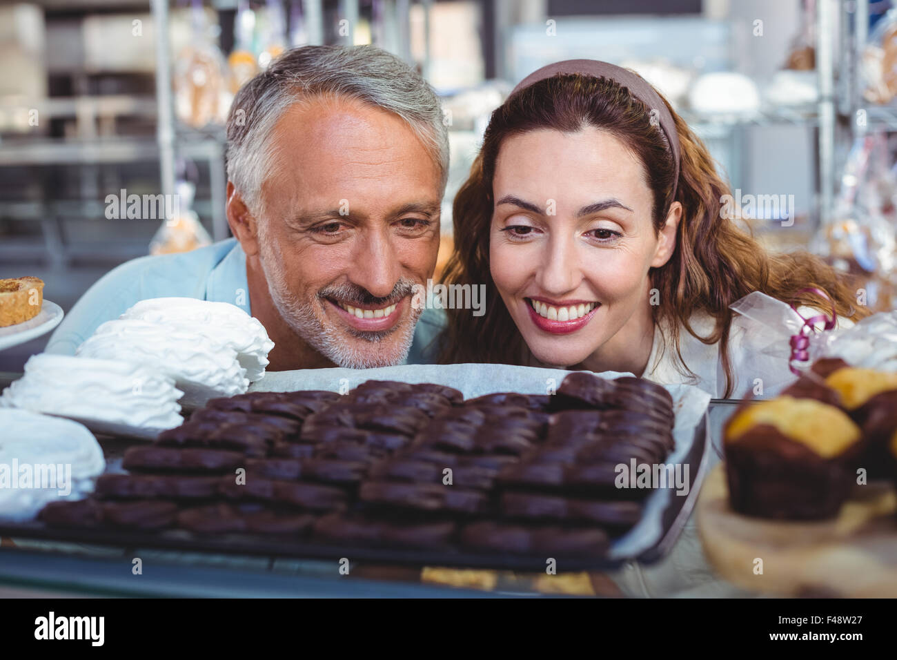 Happy couple looking at cakes Stock Photo - Alamy