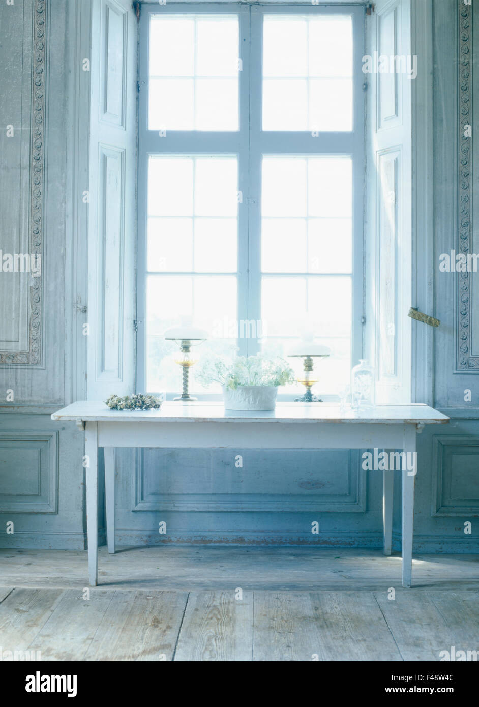 A table with flowers at a window Stock Photo - Alamy