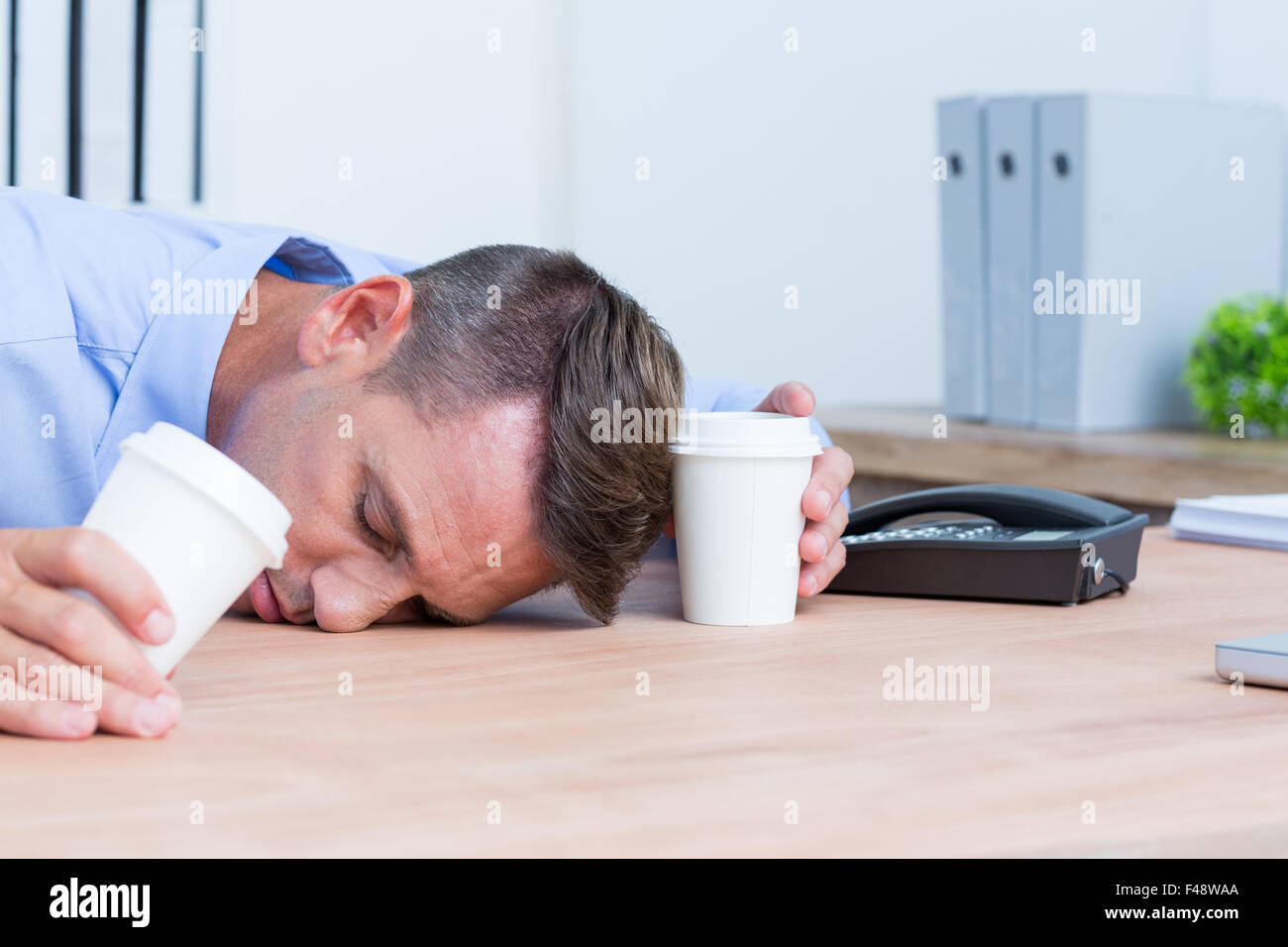 Businessman sleeping on his desk Stock Photo - Alamy