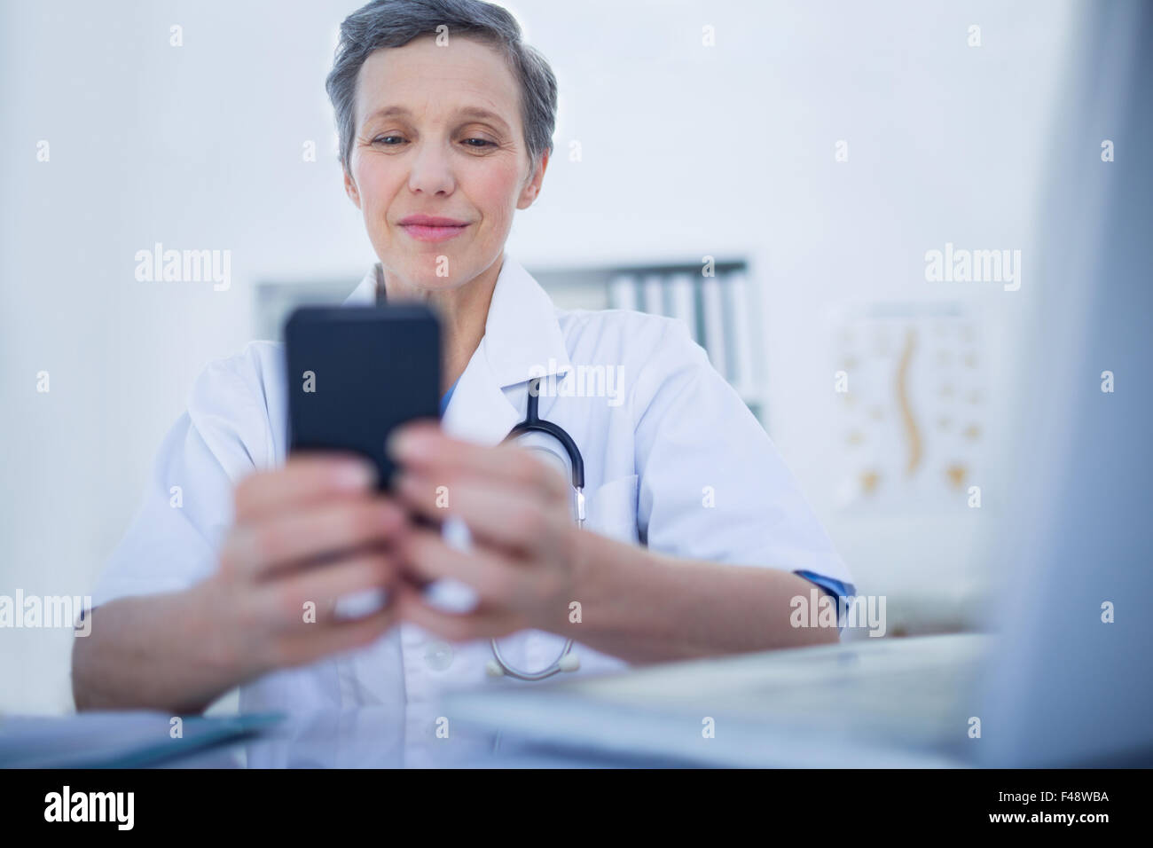 Female doctor using smartphone sitting hi-res stock photography and ...