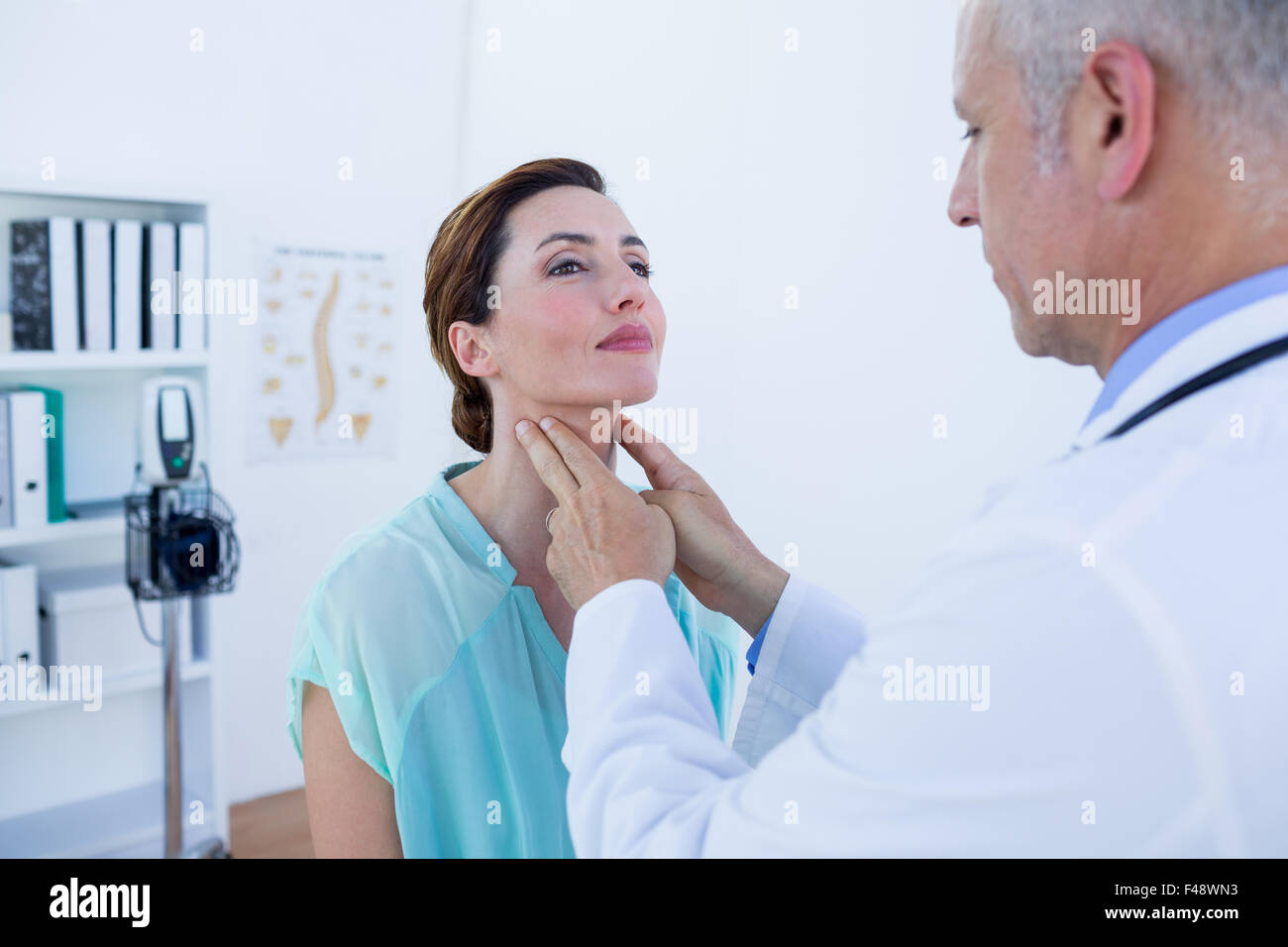 Doctor examining his patient neck Stock Photo - Alamy