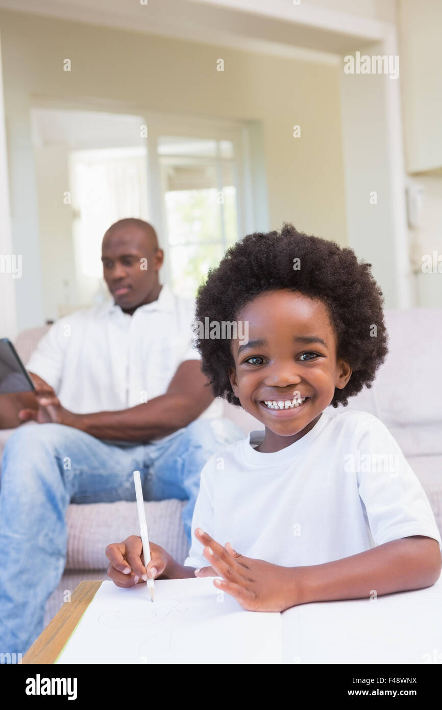 Smiling little boy writing on table Stock Photo - Alamy
