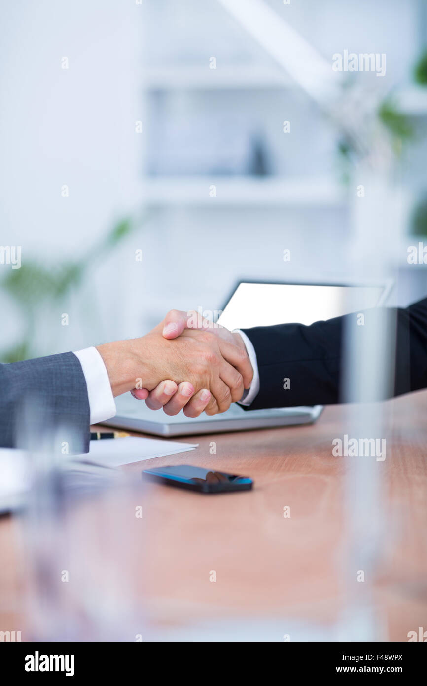 Two businessmen shaking hands and working Stock Photo - Alamy