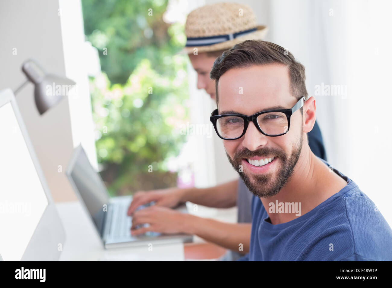 Happy handsome man looking at camera with his colleagues behind Stock ...