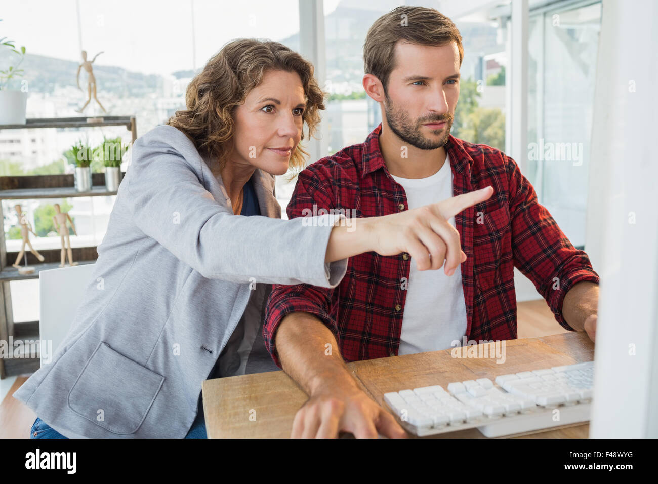 Creative business partners working on computer together Stock Photo - Alamy