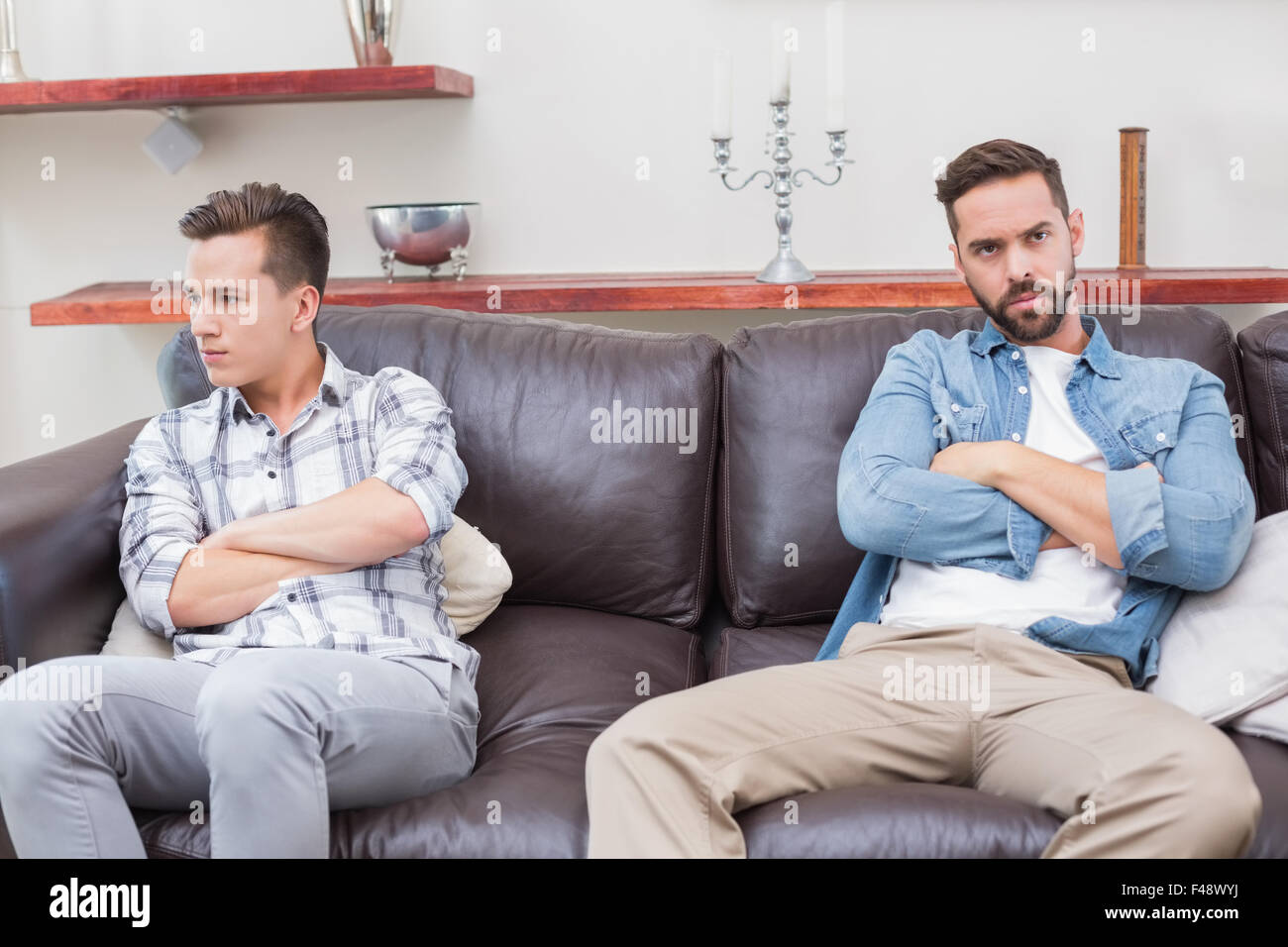 Homosexual couple men sulking in the corner Stock Photo - Alamy