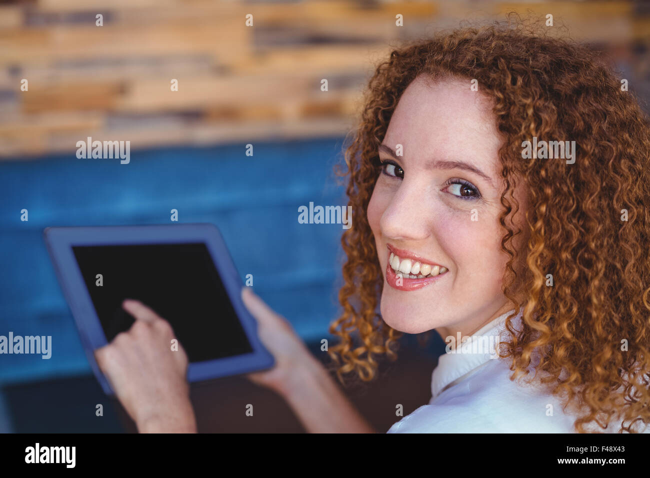Pretty girl using a small tablet at table Stock Photo - Alamy