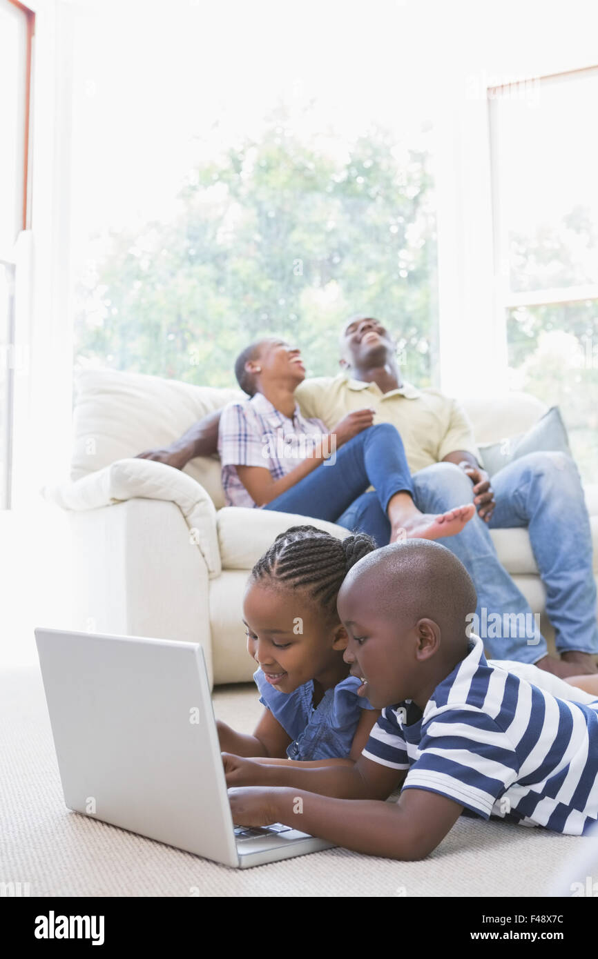 Happy siblings using their laptop Stock Photo - Alamy