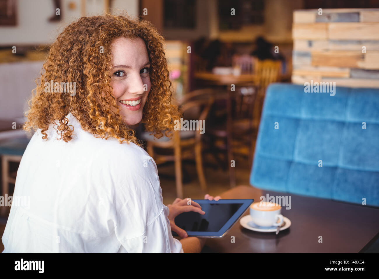 Pretty girl using a small tablet at table Stock Photo - Alamy