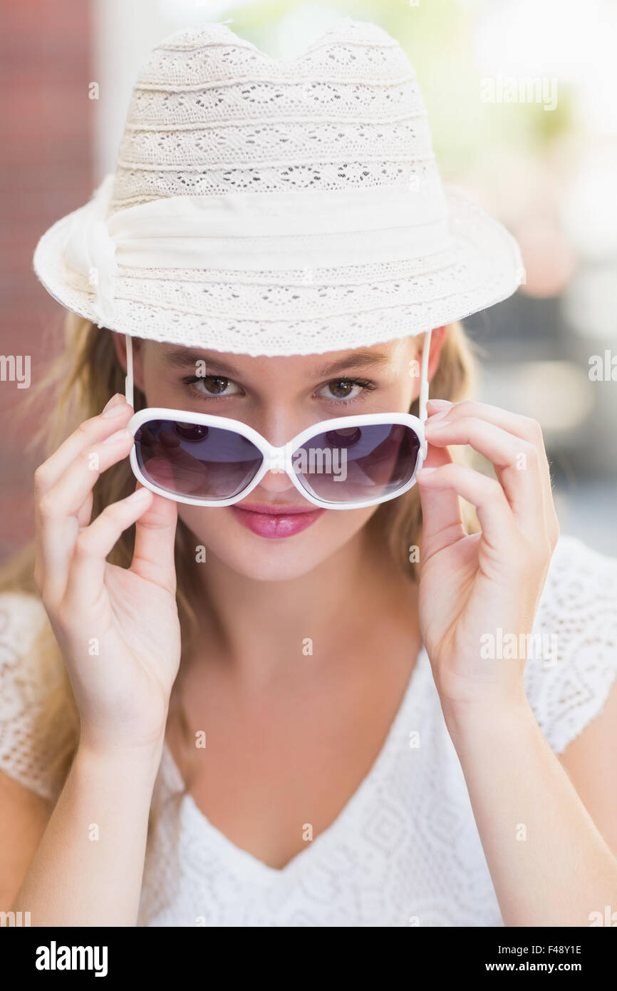 Pretty woman tilting her sunglasses Stock Photo - Alamy