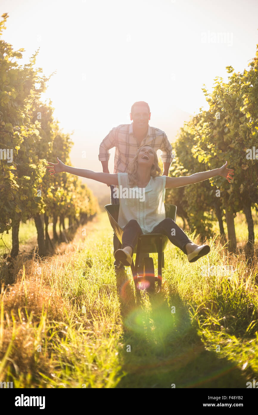 Happy couple playing with a wheelbarrow between grapevine Stock Photo ...