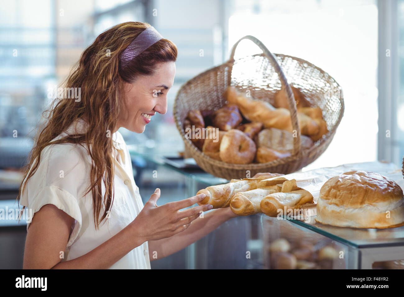 Pretty brunette pointing at loaf of bread Stock Photo - Alamy