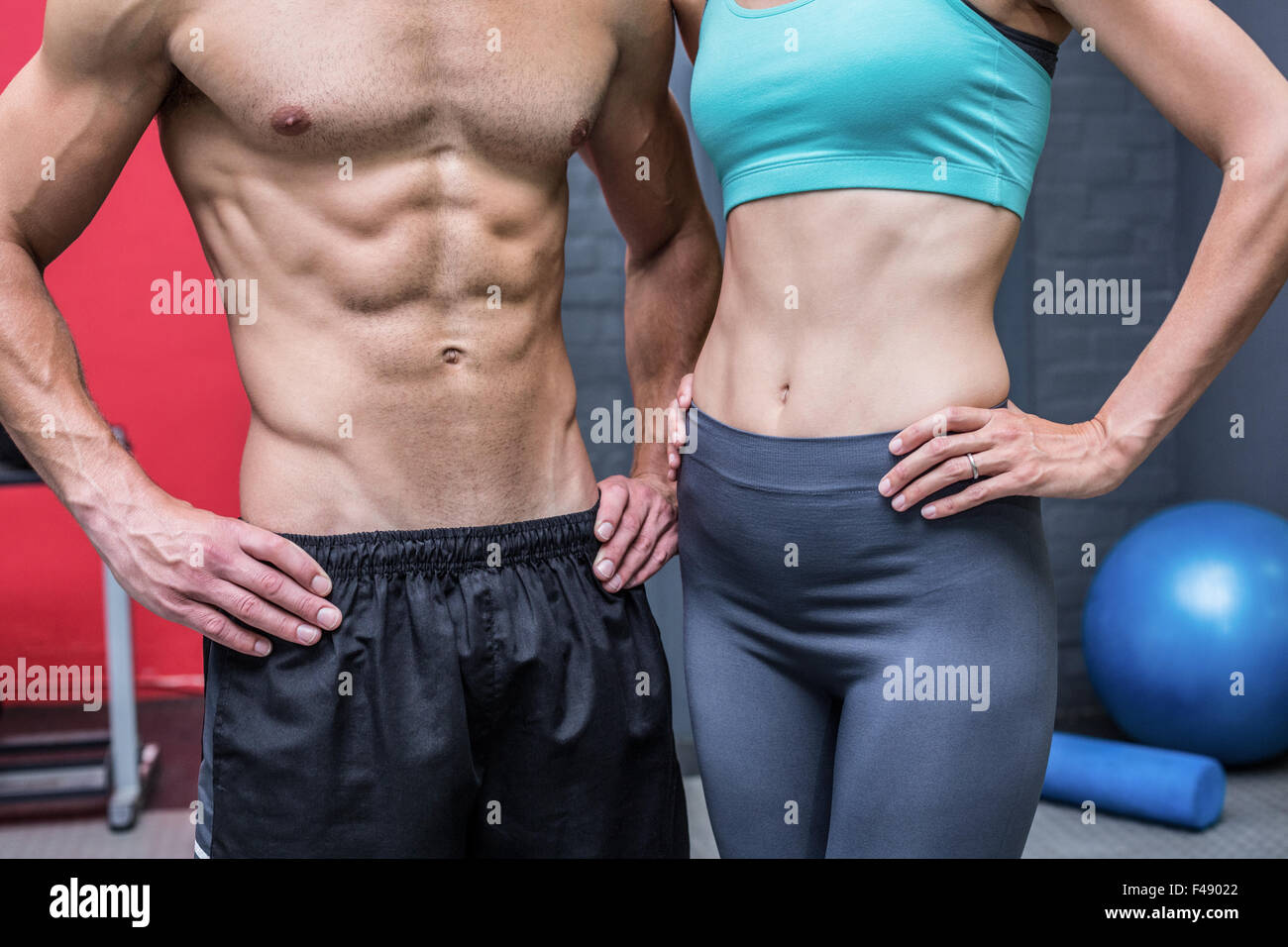 Muscular couple with hands on the hips Stock Photo - Alamy