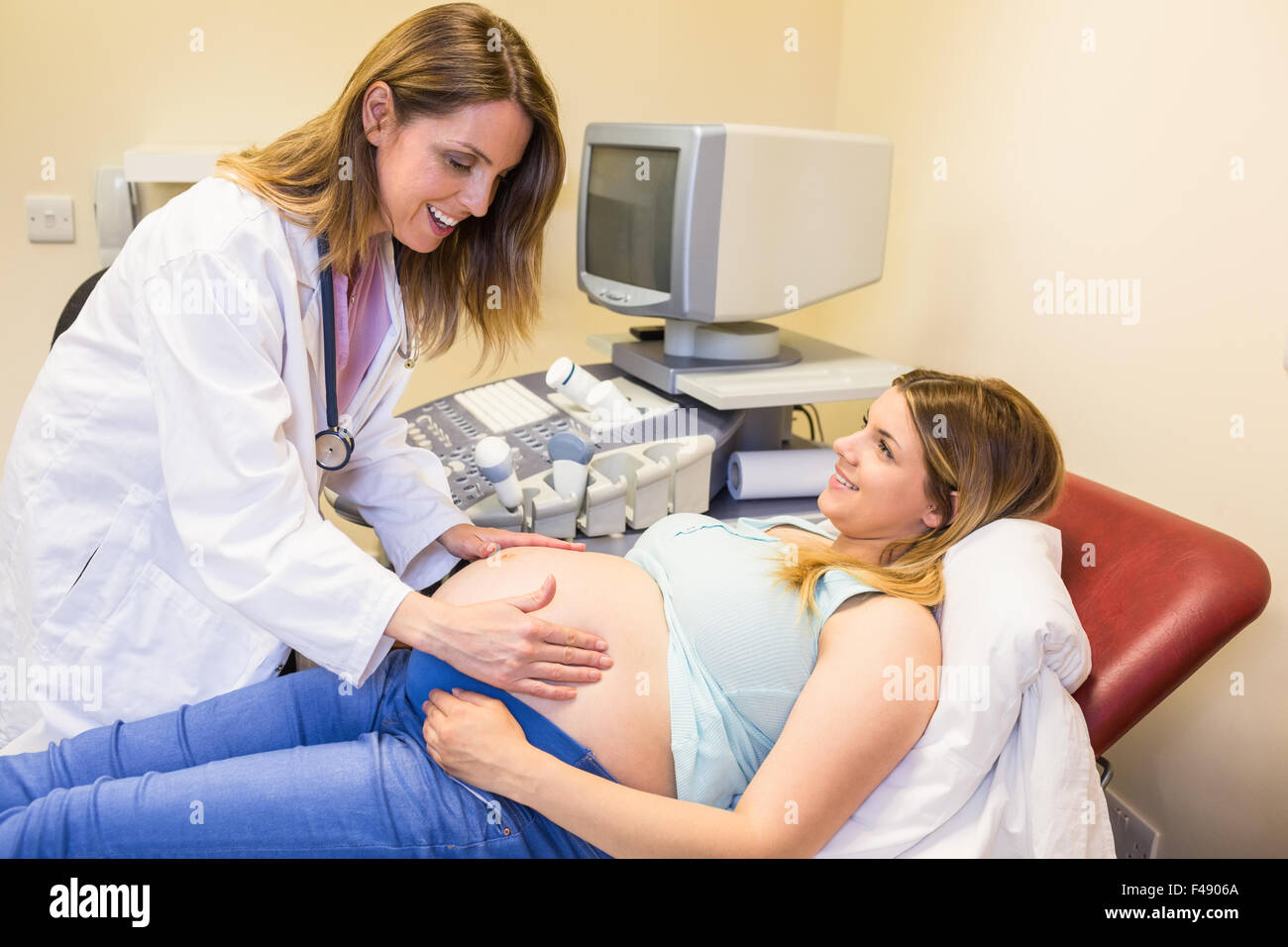Smiling doctor looking at pregnant patient Stock Photo - Alamy