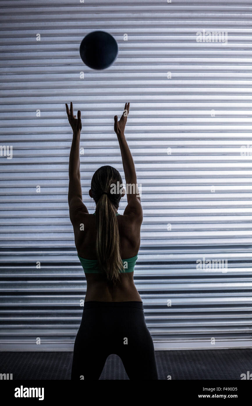 Muscular woman throwing ball in the air Stock Photo - Alamy