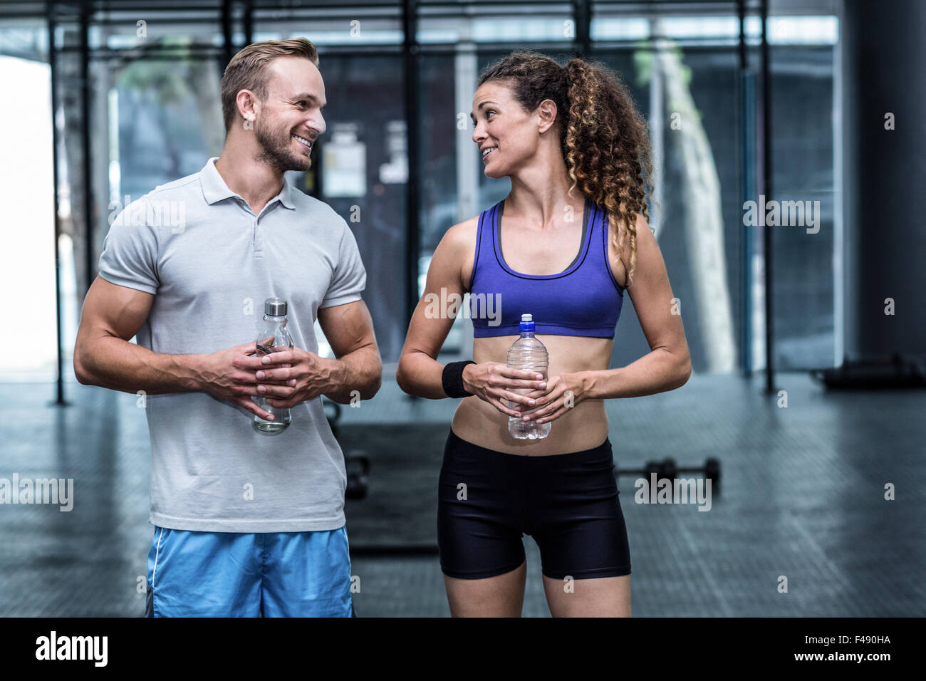 Muscular woman discussing with trainer Stock Photo - Alamy