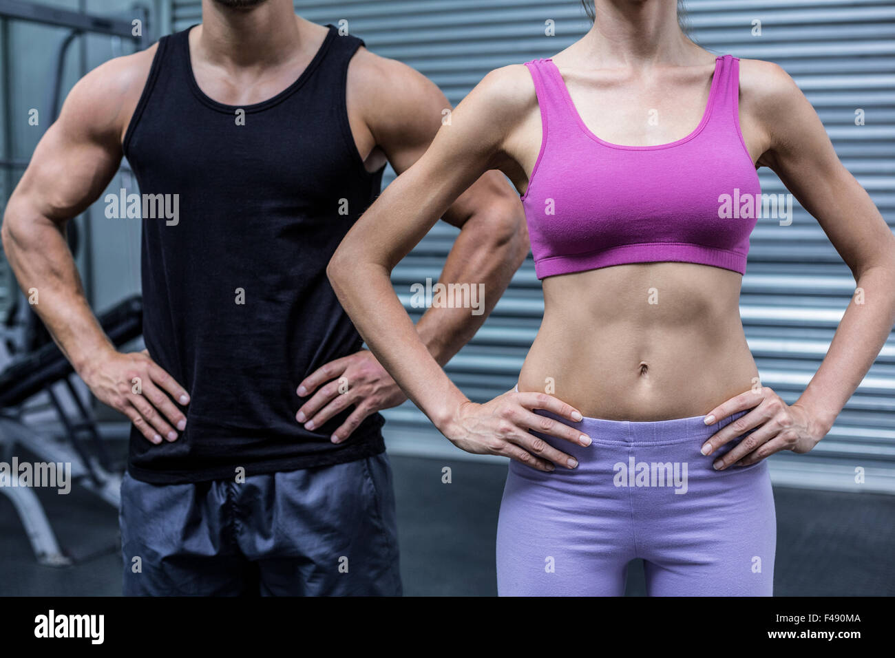 Muscular couple with hands on the hips Stock Photo - Alamy