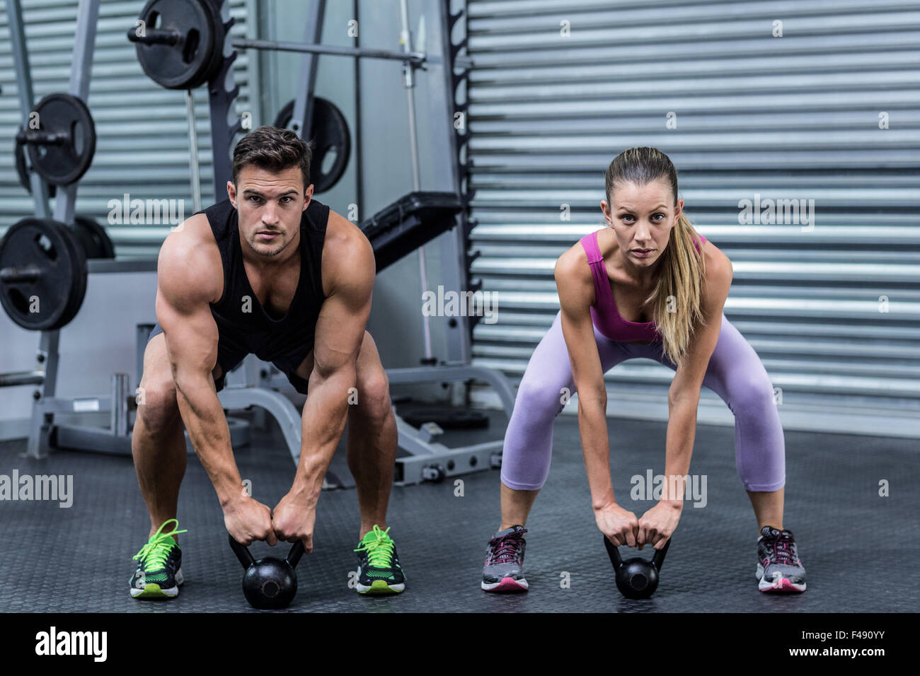 A muscular couple lifting kettlebells Stock Photo - Alamy