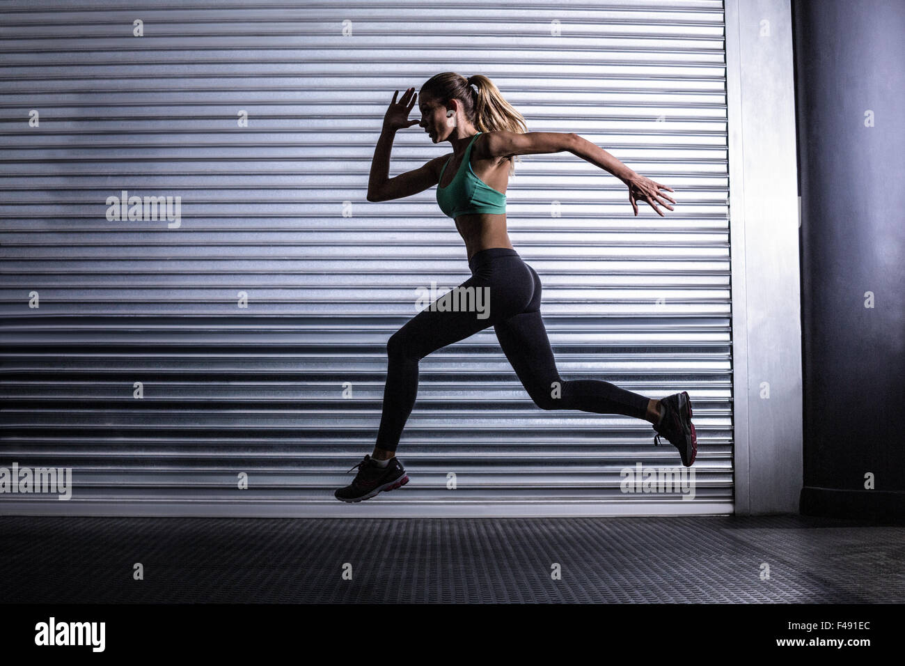 Muscular woman running in exercise room Stock Photo - Alamy
