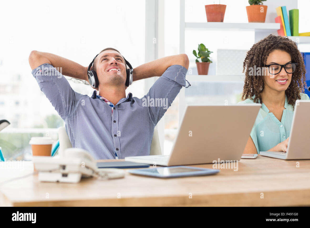 Relaxed businessman listening to music Stock Photo - Alamy