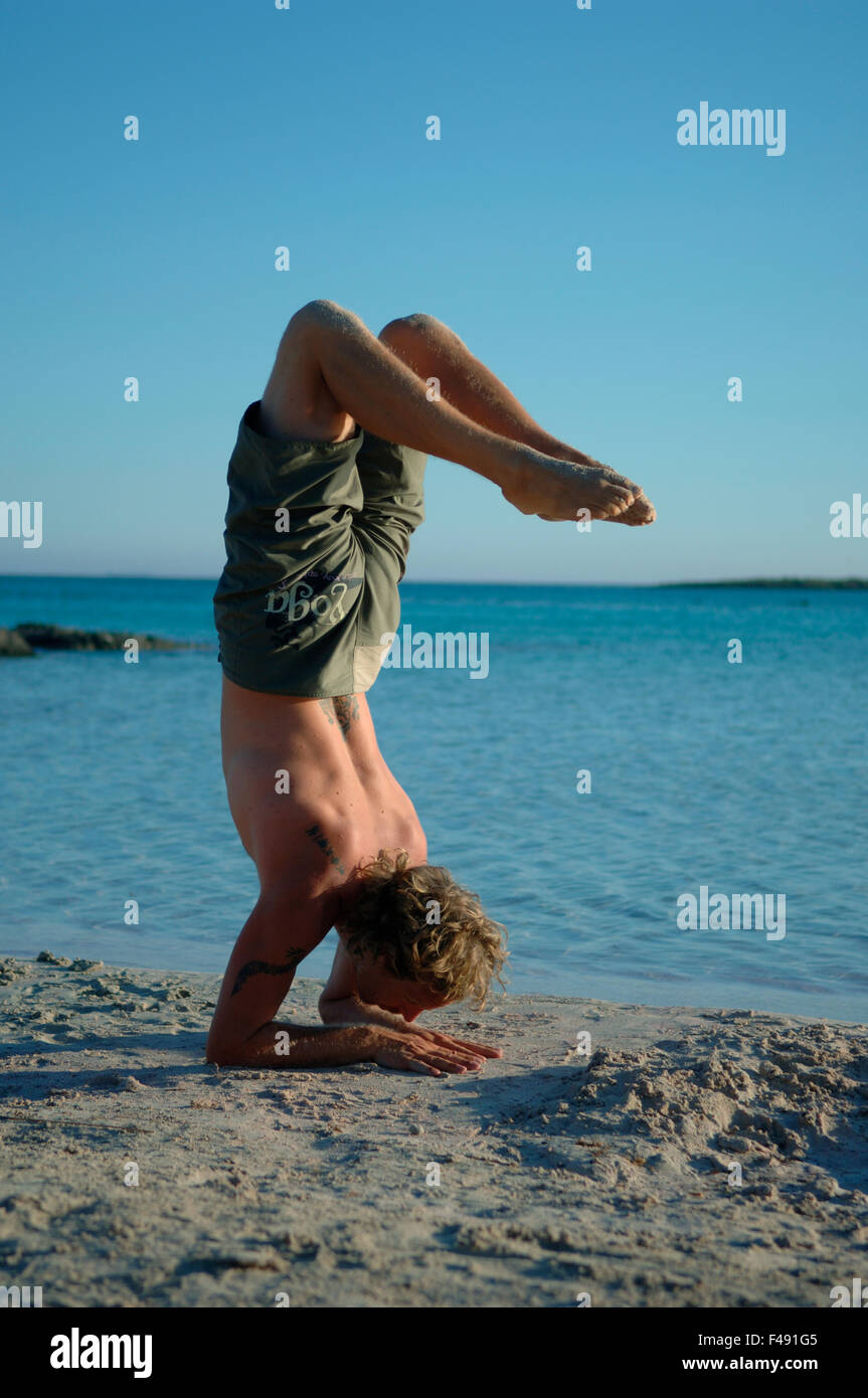 Man performing yoga on a beach, Greece Stock Photo - Alamy