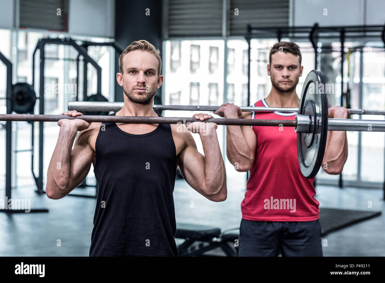 Muscular men lifting a barbell Stock Photo - Alamy