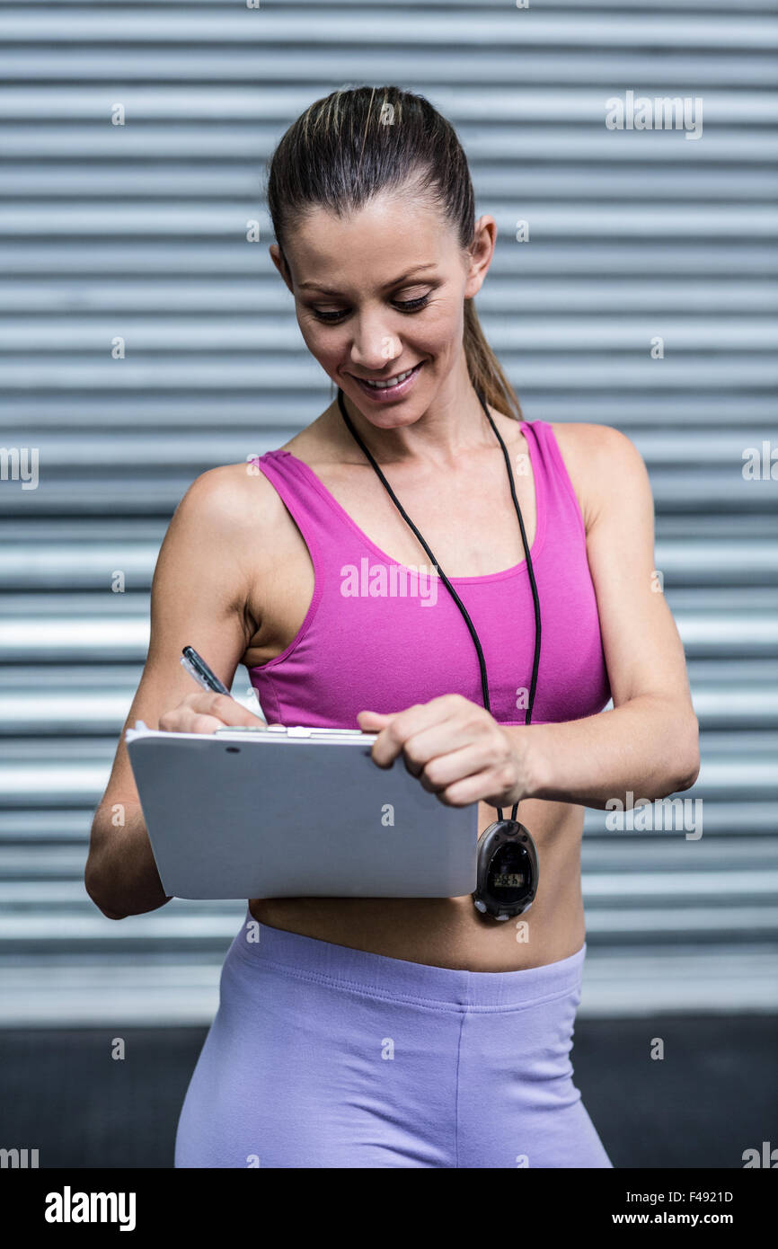 A female coach writing on her clipboard Stock Photo - Alamy