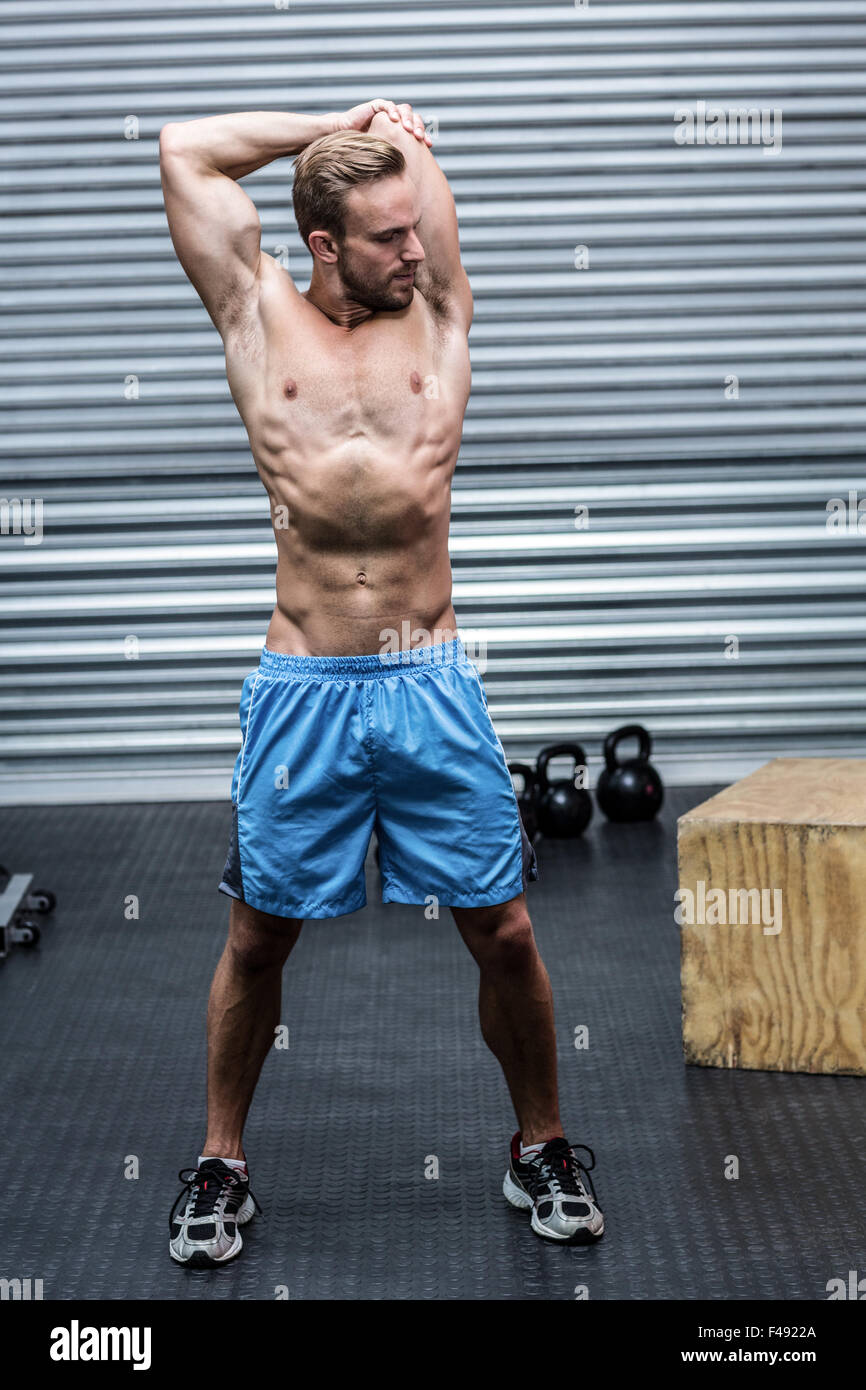 Muscular man doing arm stretchings Stock Photo - Alamy