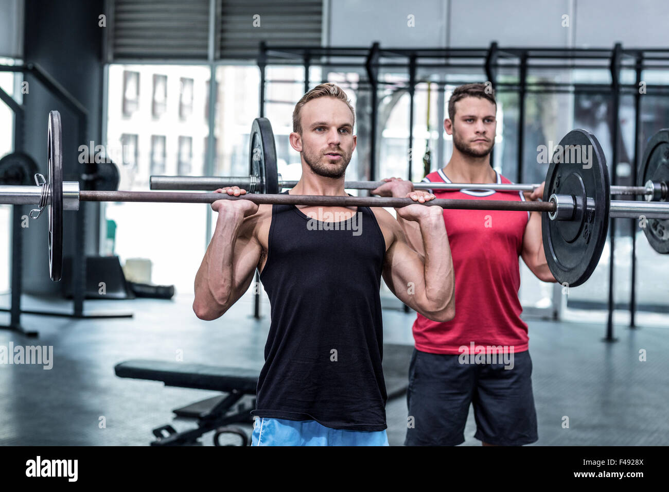 Muscular men lifting a barbell Stock Photo - Alamy