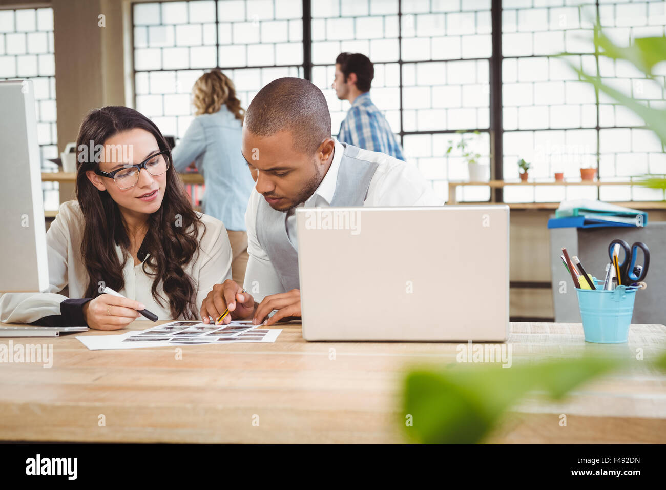 Colleagues looking at document Stock Photo - Alamy