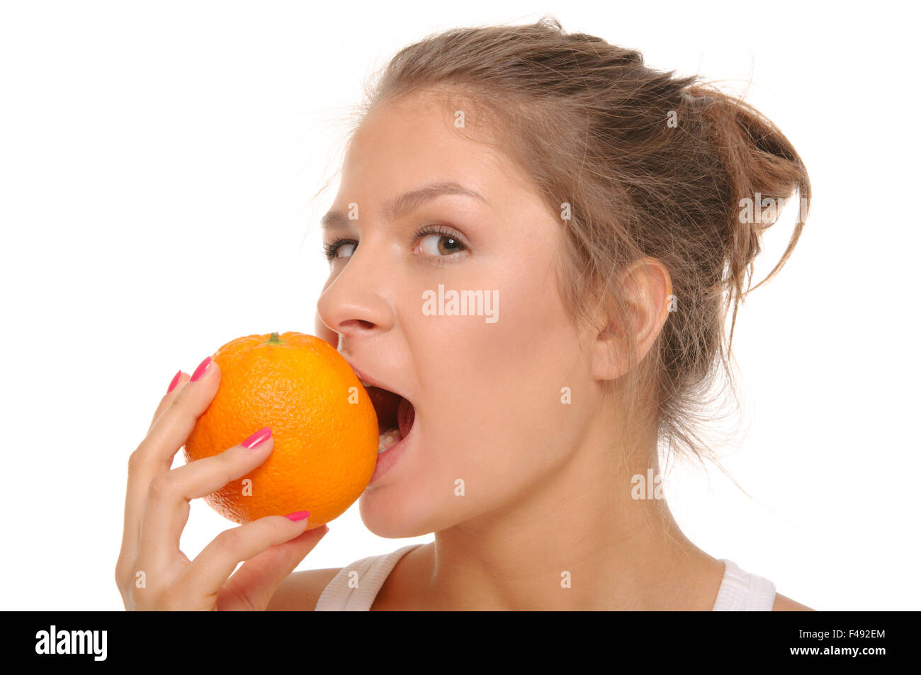 Young woman bites an orange Stock Photo - Alamy
