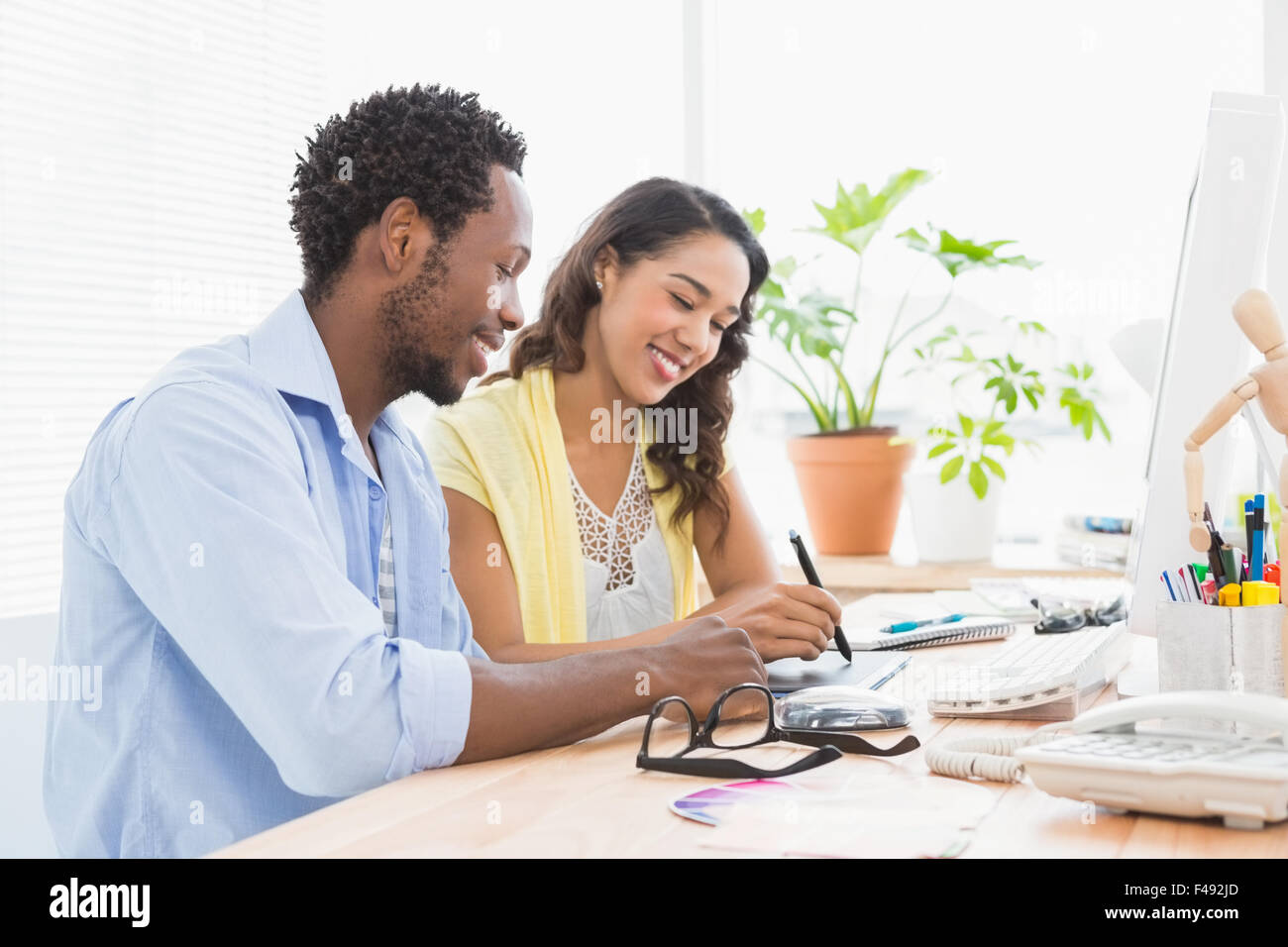 Smiling colleagues working together Stock Photo - Alamy