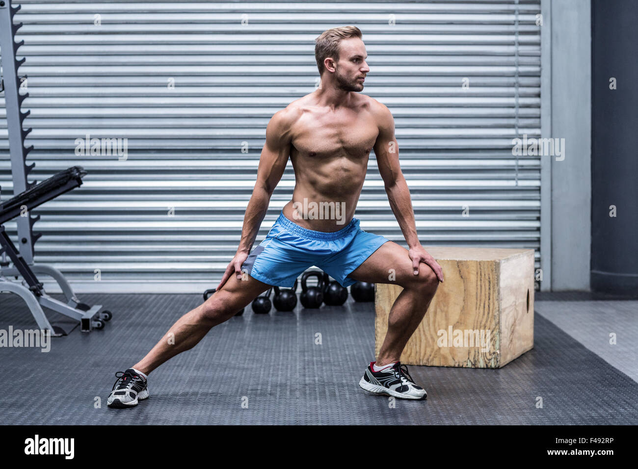 Muscular man doing leg stretchings Stock Photo - Alamy