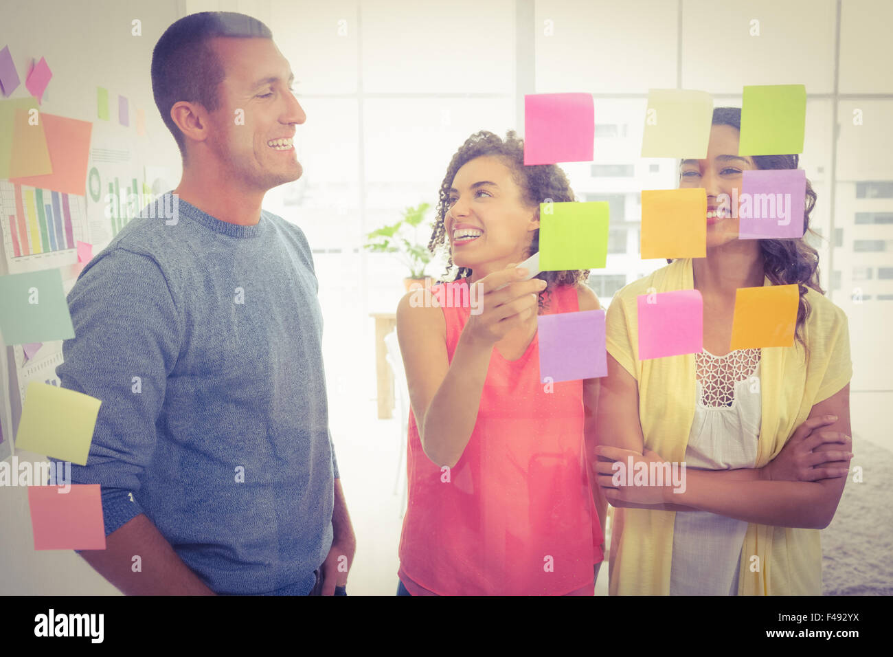 Smiling coworkers pointing sticky notes Stock Photo - Alamy