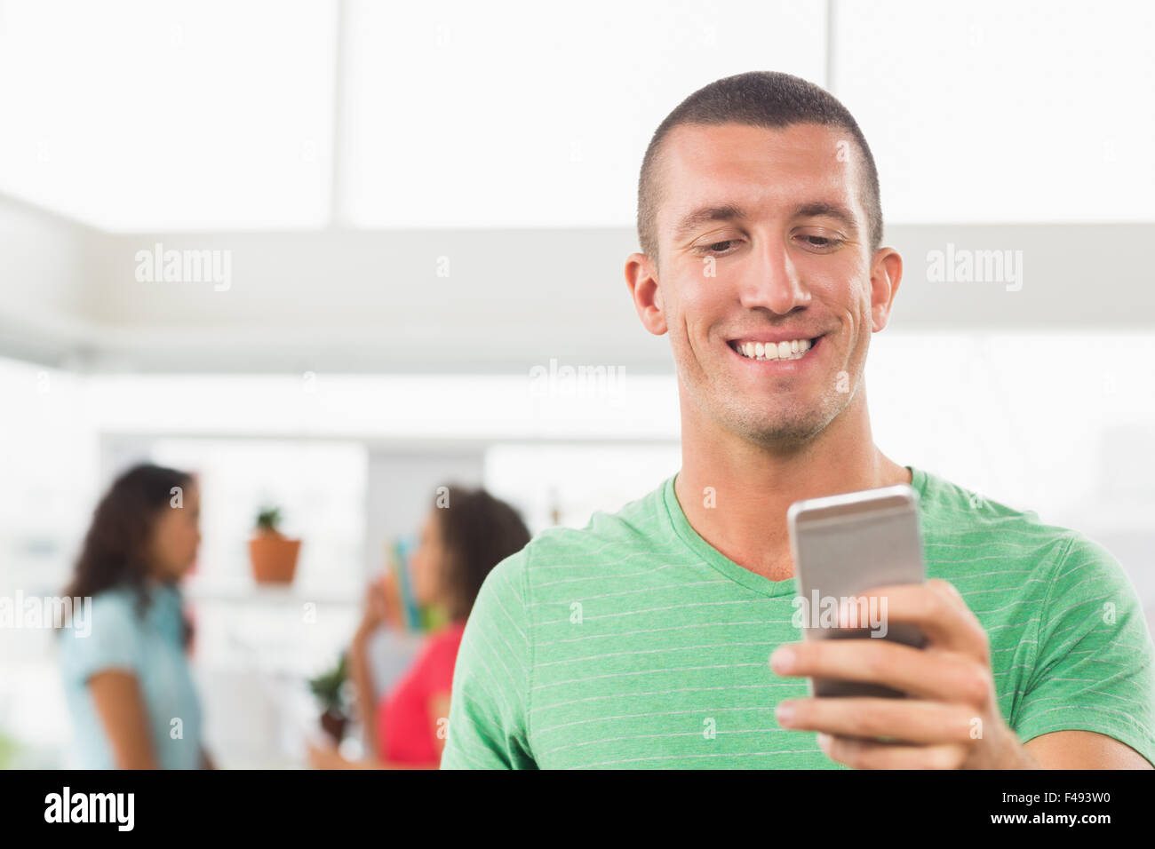 Casual businessman text messaging in office Stock Photo - Alamy